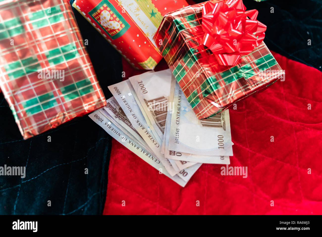 Nigerian Naira notes under Christmas Tree with wrapped presents Stock ...