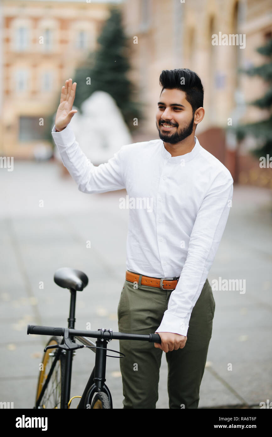 Young hipster man with fixed gear bike waving hand on city street Stock ...
