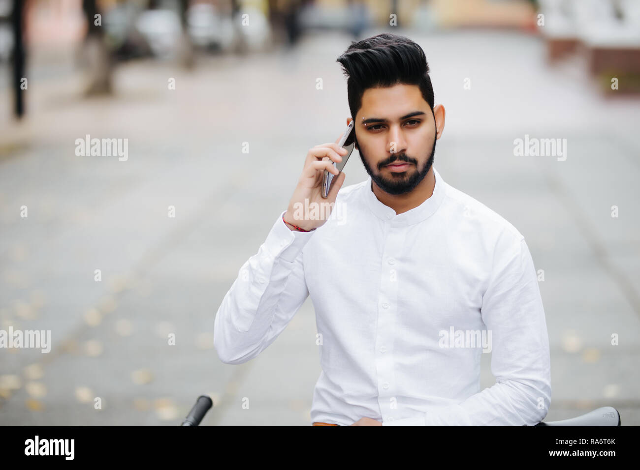 Happy young indian man talking on his cellphone in the city Stock Photo ...