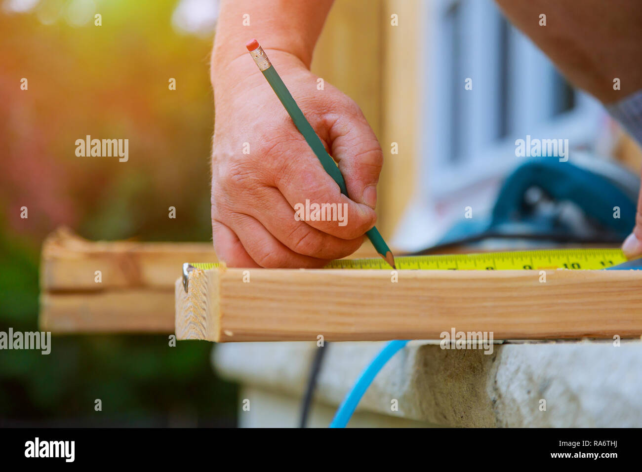 Carpenter using the writes a pencil on the wood beam a new home ...