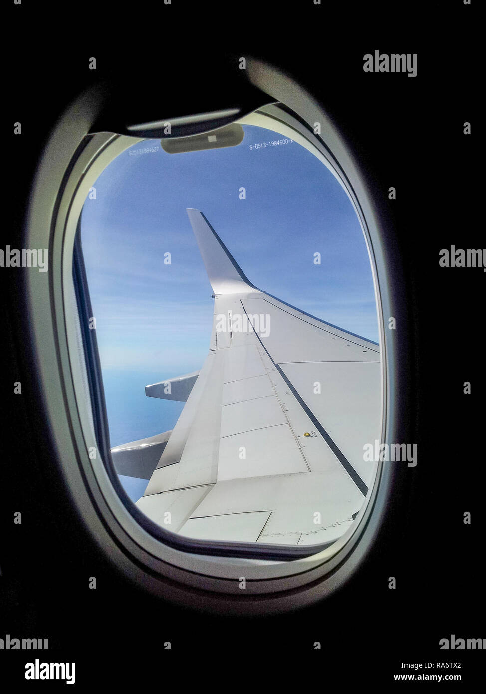 Wing through a jet airliner window Stock Photo - Alamy
