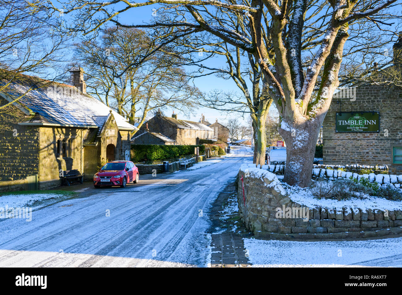 View of icy & snow covered main street (with pub & hall) in small ...