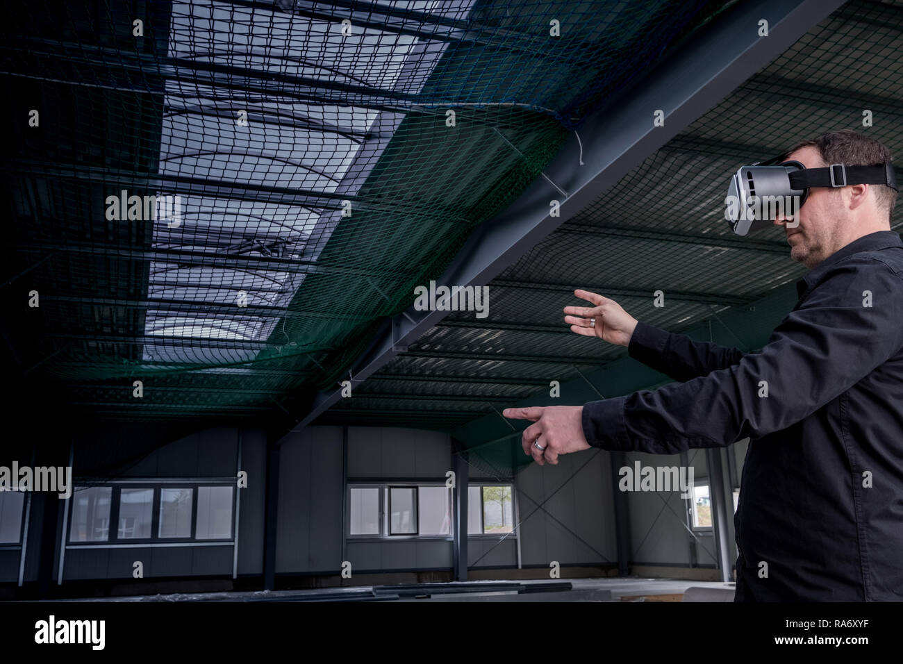 Construction worker standing at indoor construction site wearing vr ...