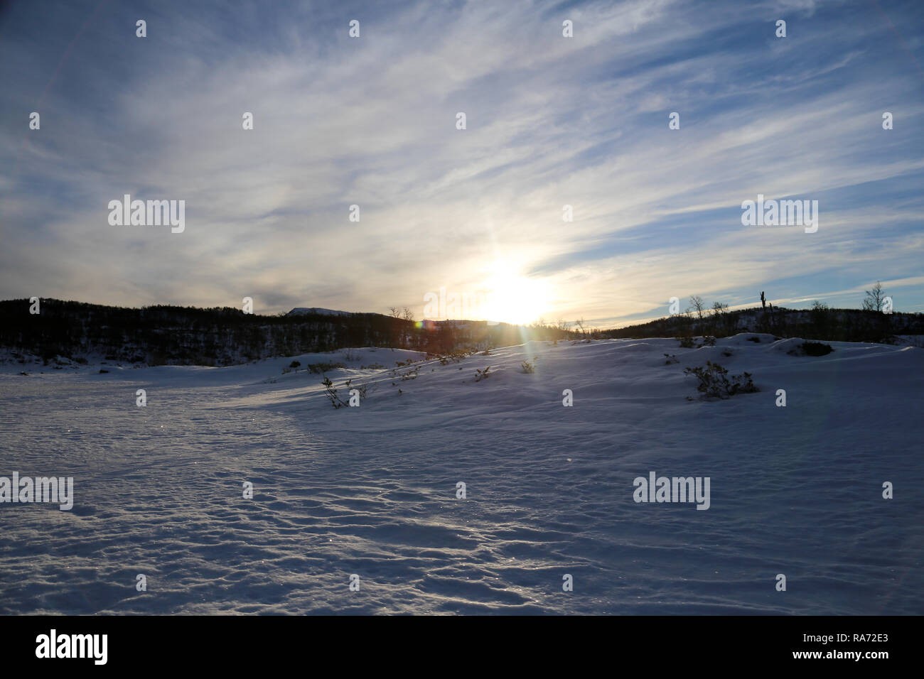 Sun rising over mountain side over snow scene Stock Photo - Alamy