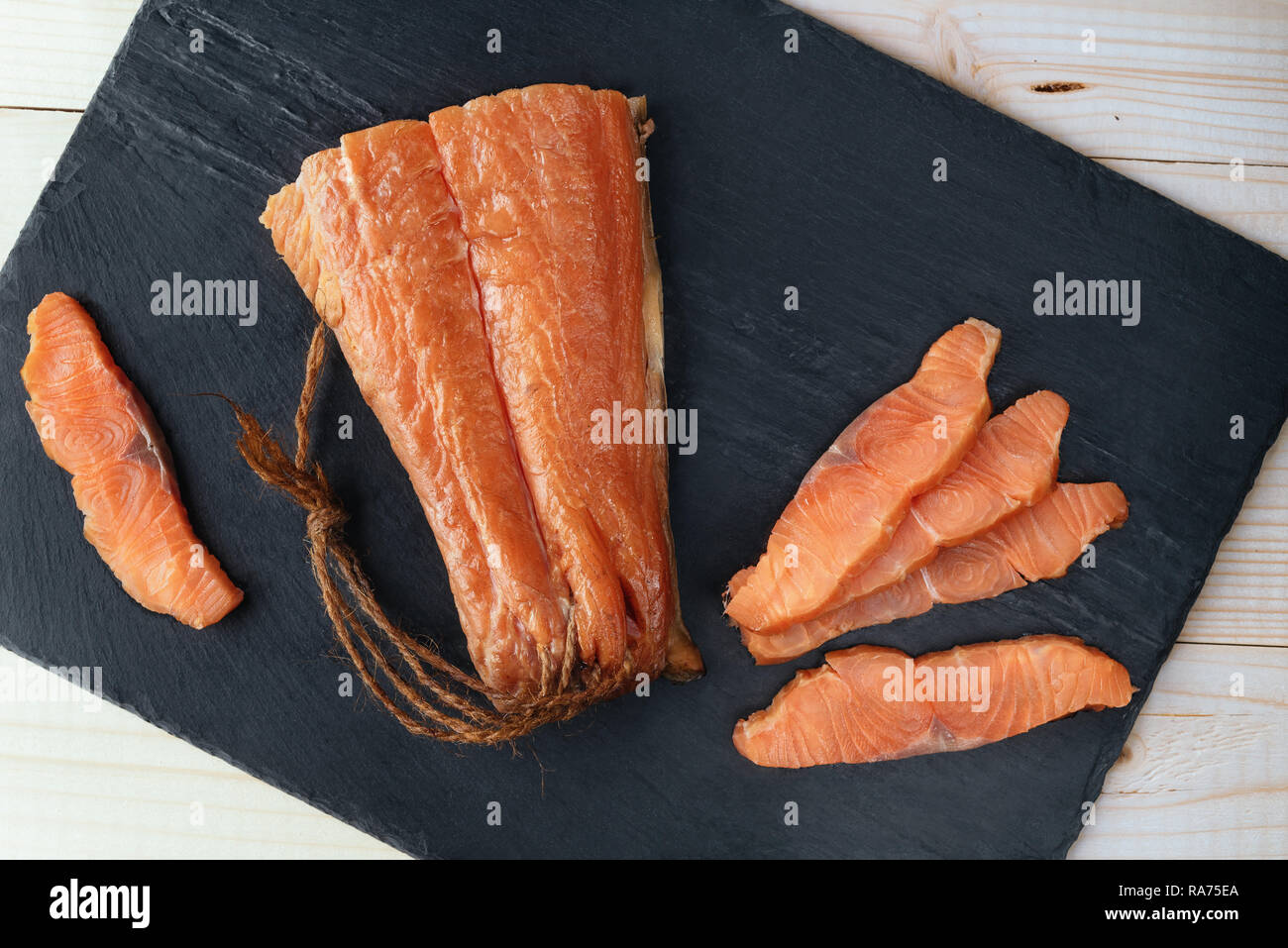 Smoked salmon fish on a slate board. Top view at cutted slices of ...
