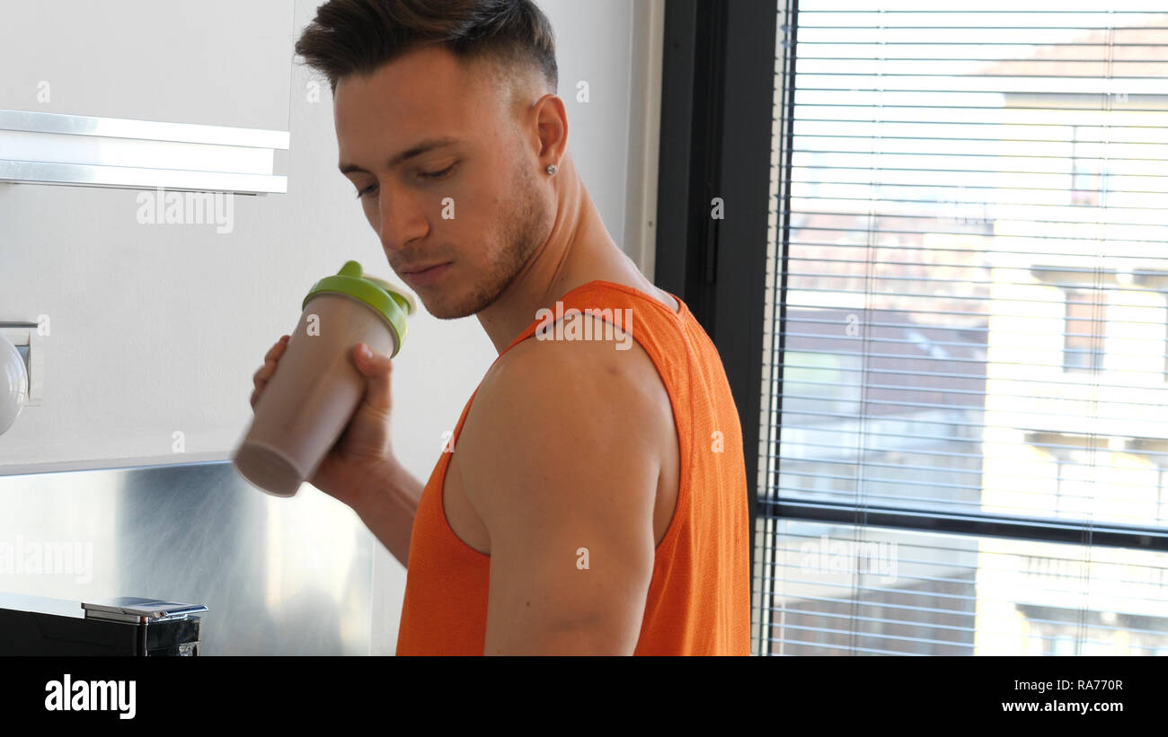 Young man drinking a smoothie drink or a protein shake Stock Photo - Alamy