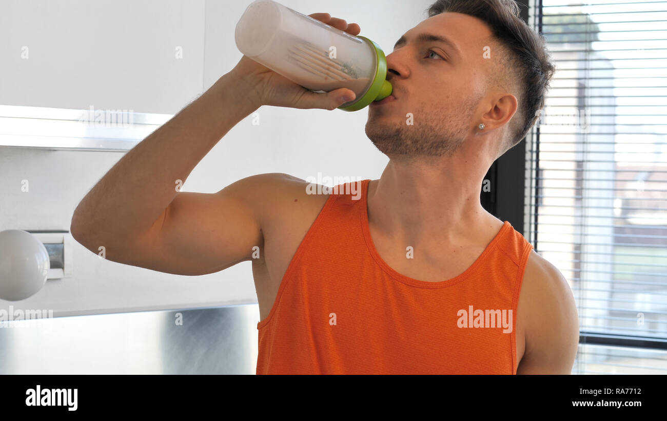Young man drinking a smoothie drink or a protein shake Stock Photo - Alamy