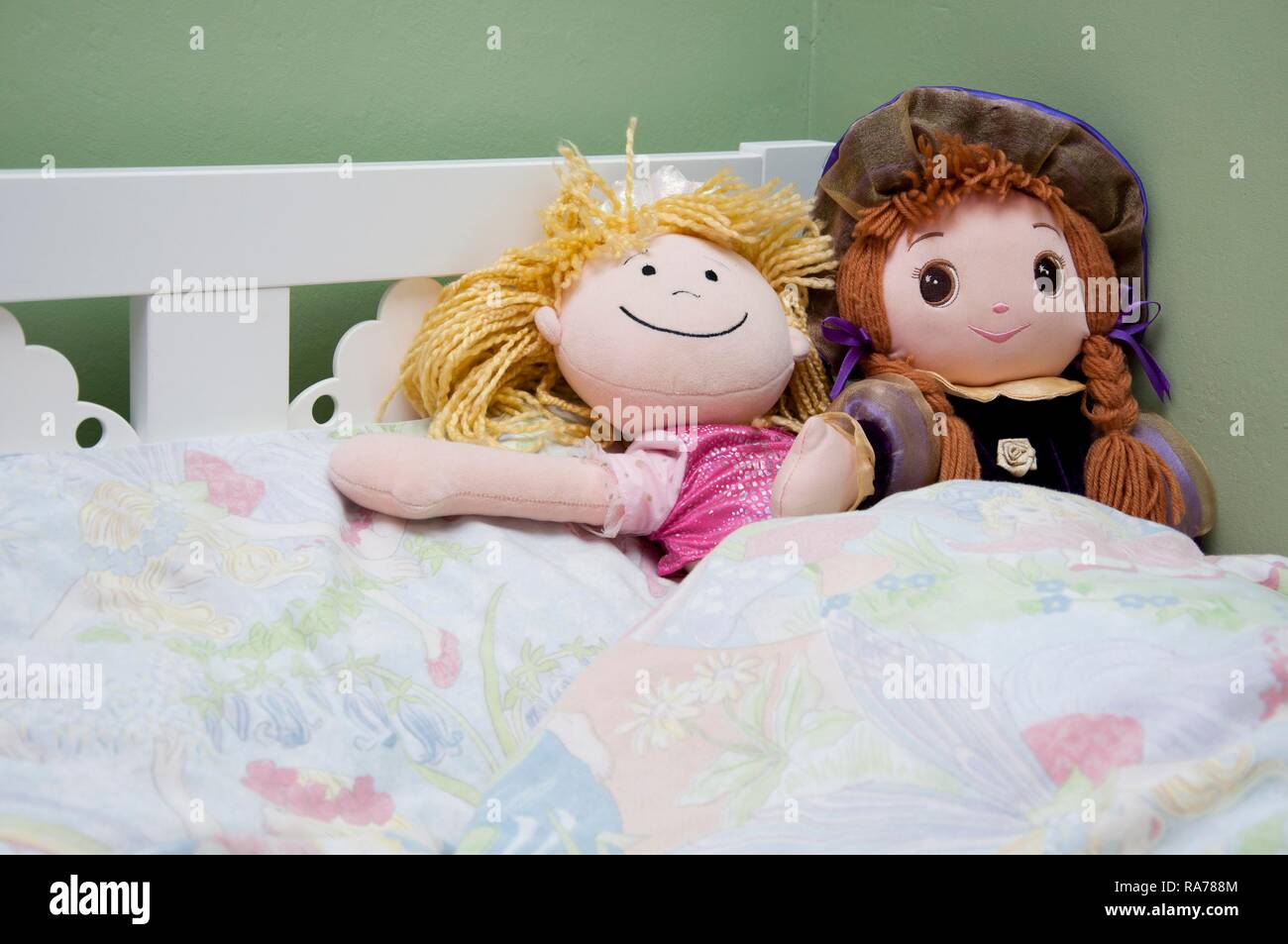 Two dolls on a child's bed Stock Photo - Alamy
