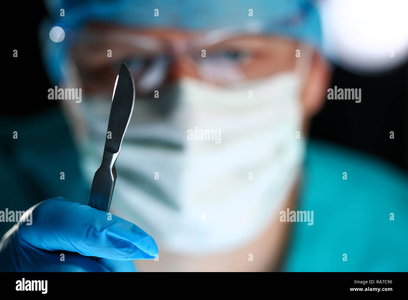 Surgeon arms in sterile uniform holding sharp knife Stock Photo - Alamy