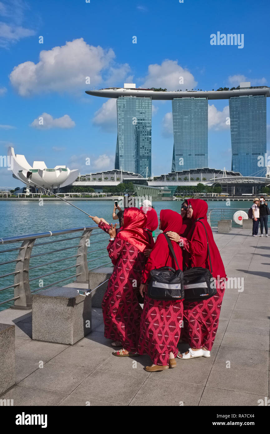 Female Indonesian tourists at Merlion Park by Marina Bay, Singapore ...