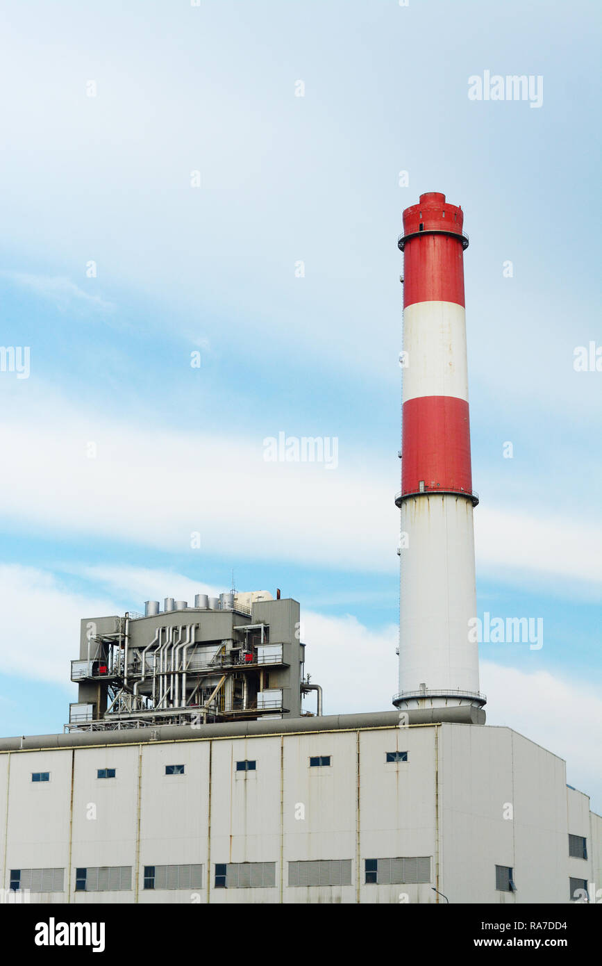 White and red vertical pipe flue-gas stack of power plant with blue sky ...