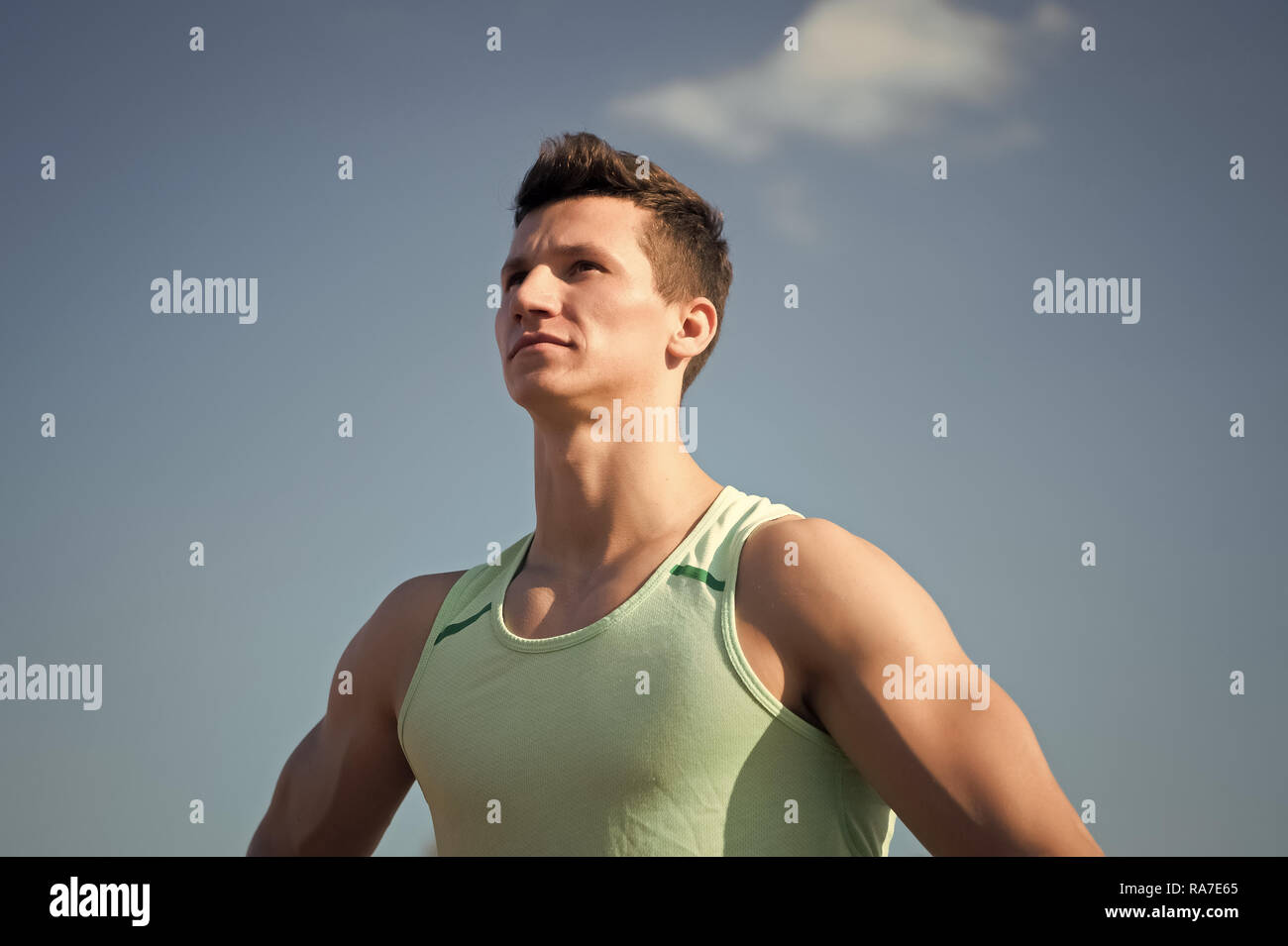 Athlete in green tshirt on sunny day. Fitness model with muscular hands ...