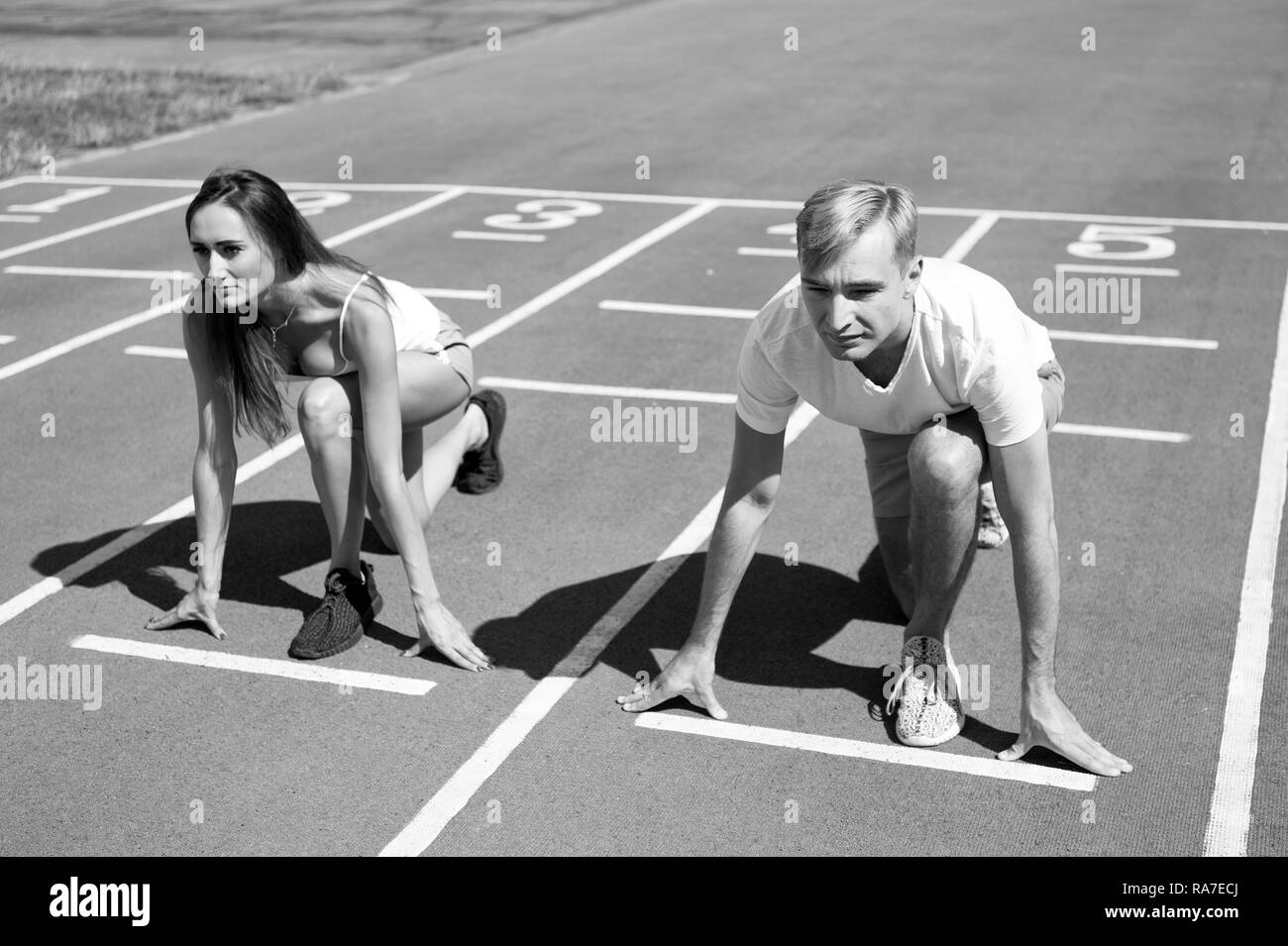 Man and woman low start position running surface stadium. Running ...