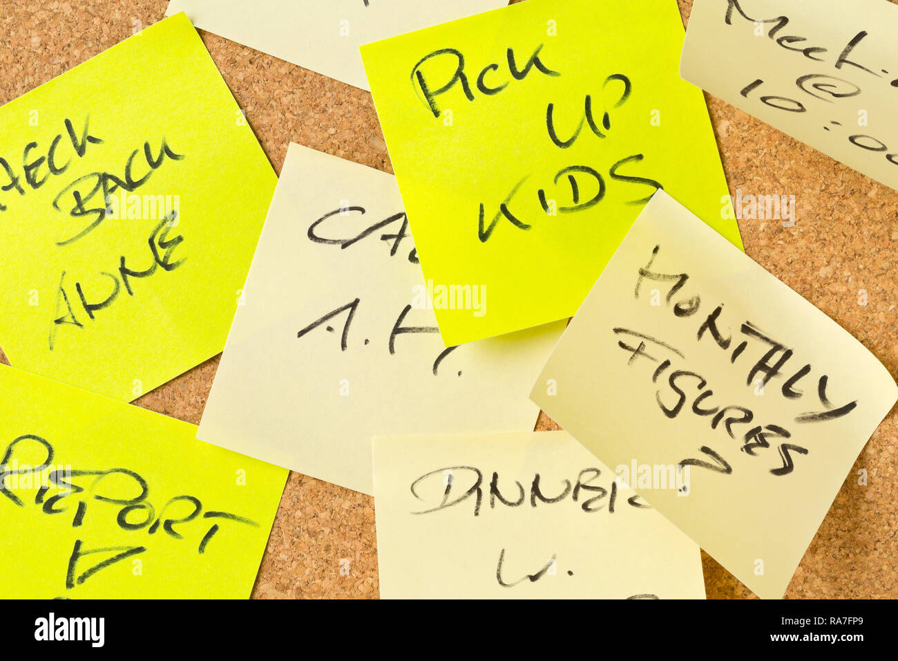 Cork memo board covered with sticky notes with different appointments ...