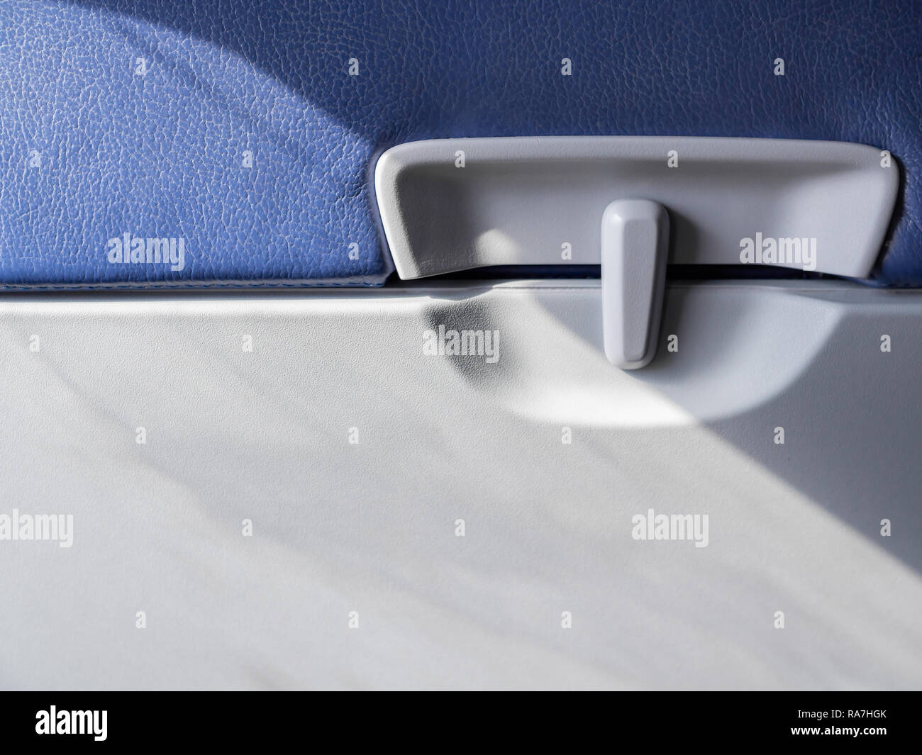 Close up lock of plastic food tray on the back of blue leather seats on ...
