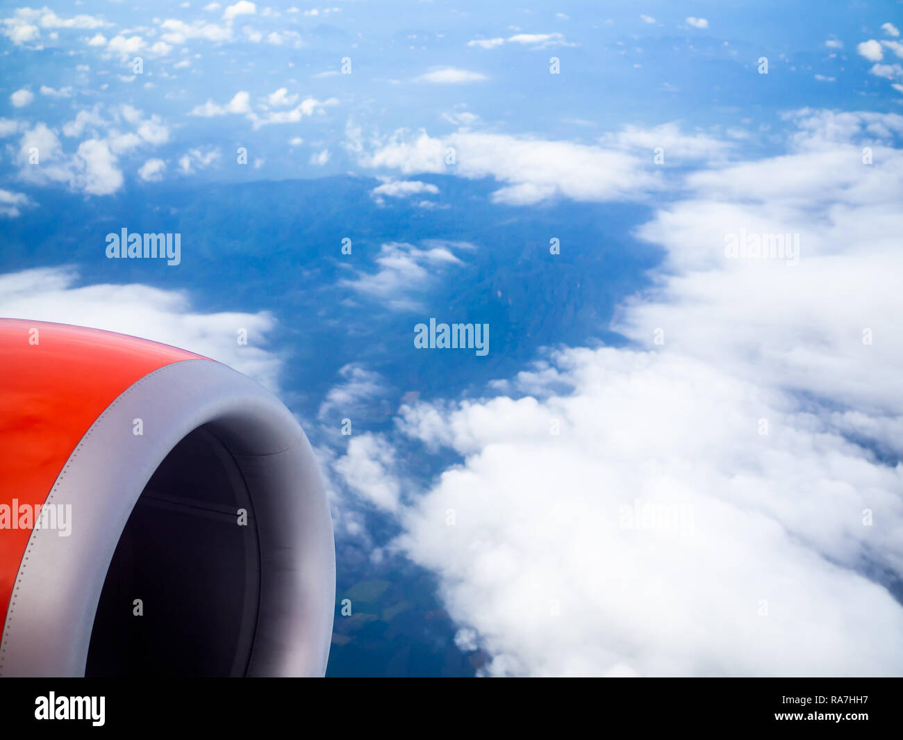 Jet engine of red airplane from window of passenger view on clouds and ...