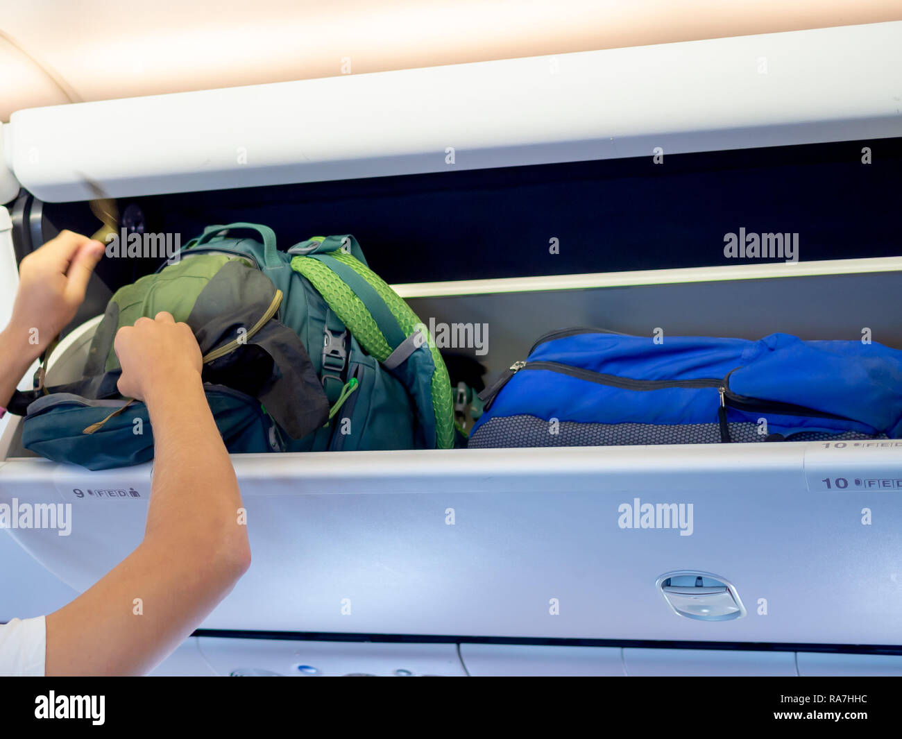 Passenger hand putting green backpack on locker number 10 in the ...