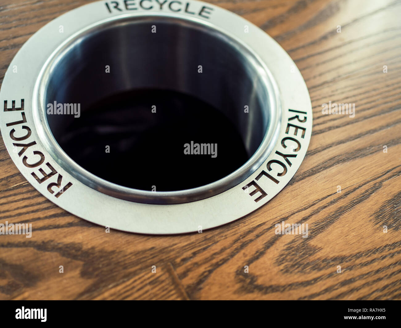 Close-up modern round recycle trash bin hole on wooden background in ...