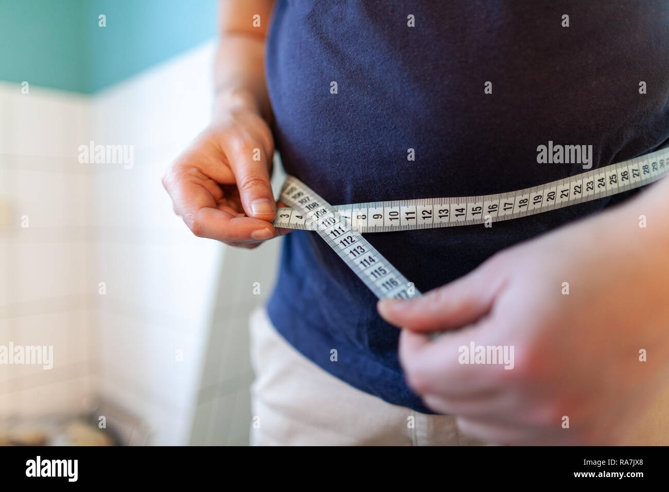 man measures her abdomen with a measuring tape Stock Photo - Alamy