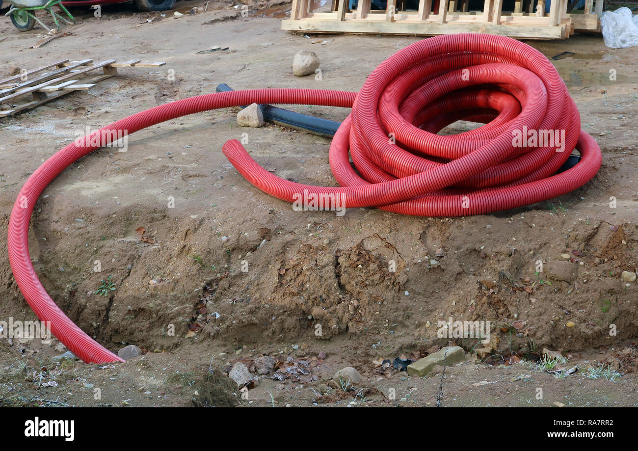 Red armed plastic pipes for a drainage and melioration lie on a city ...