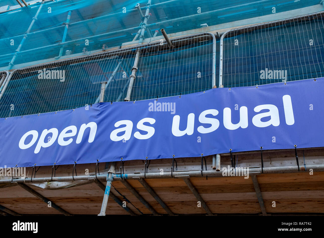 Shop in scaffolding with open as usual sign Stock Photo - Alamy