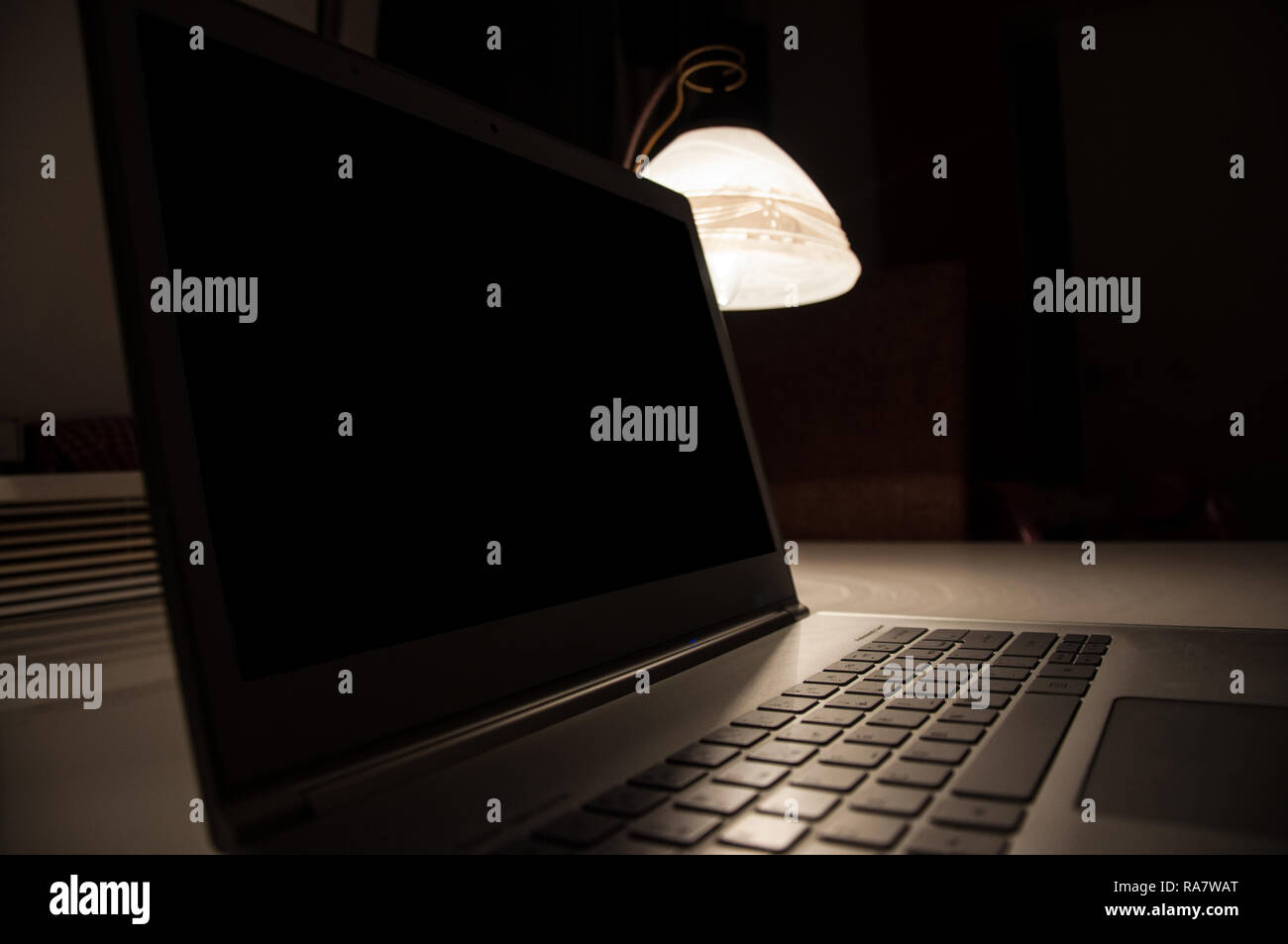Laptop and lamp on the desk in empty workplace Stock Photo - Alamy
