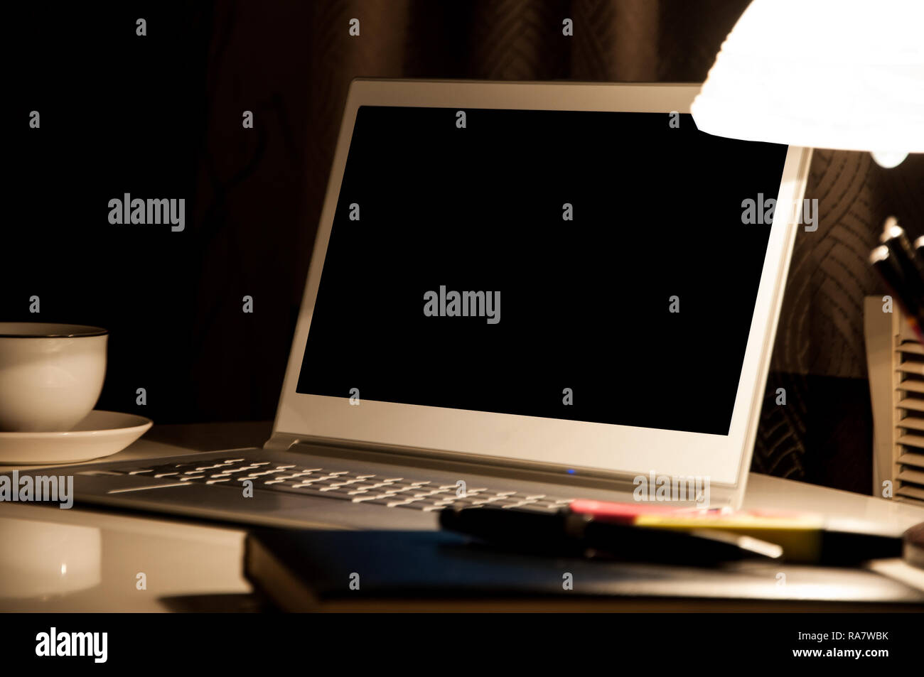 Laptop and lamp on the desk in empty workplace Stock Photo - Alamy