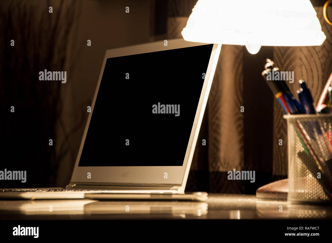 Laptop and lamp on the desk in empty workplace Stock Photo - Alamy
