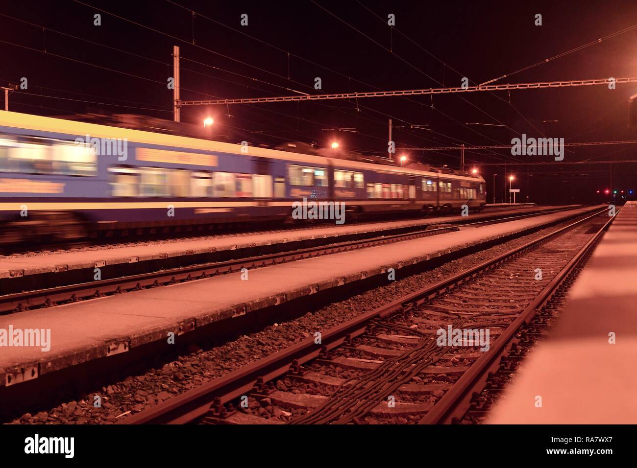 Passenger train on railroad tracks at night Blurred motion Stock Photo ...