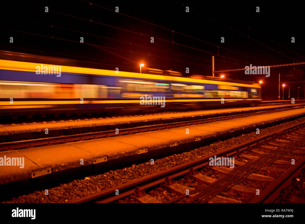 Passenger train on railroad tracks at night Blurred motion Stock Photo ...