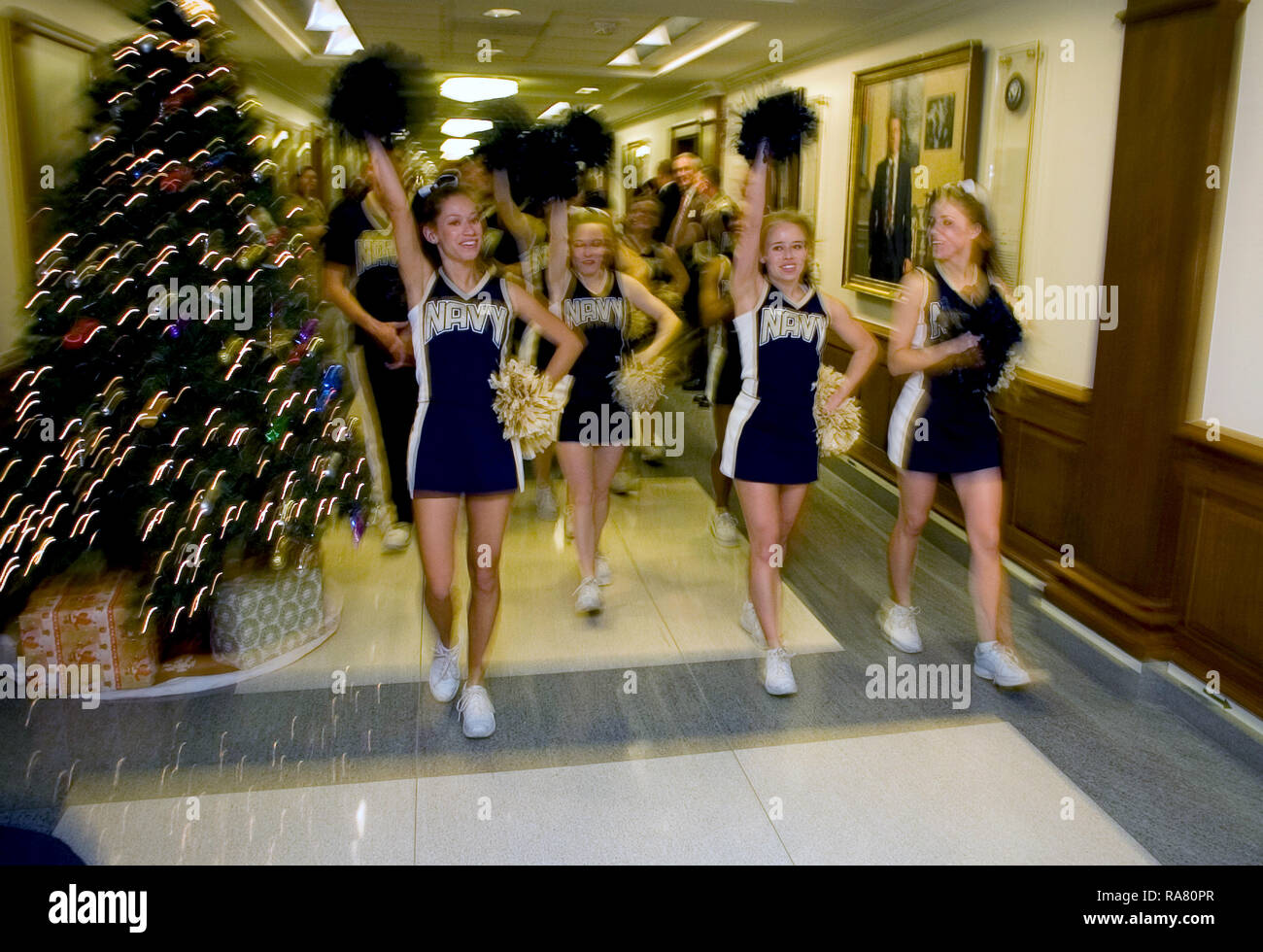 Members of the U.S. Naval Academy Midshipmen Cheerleaders and Band stir ...