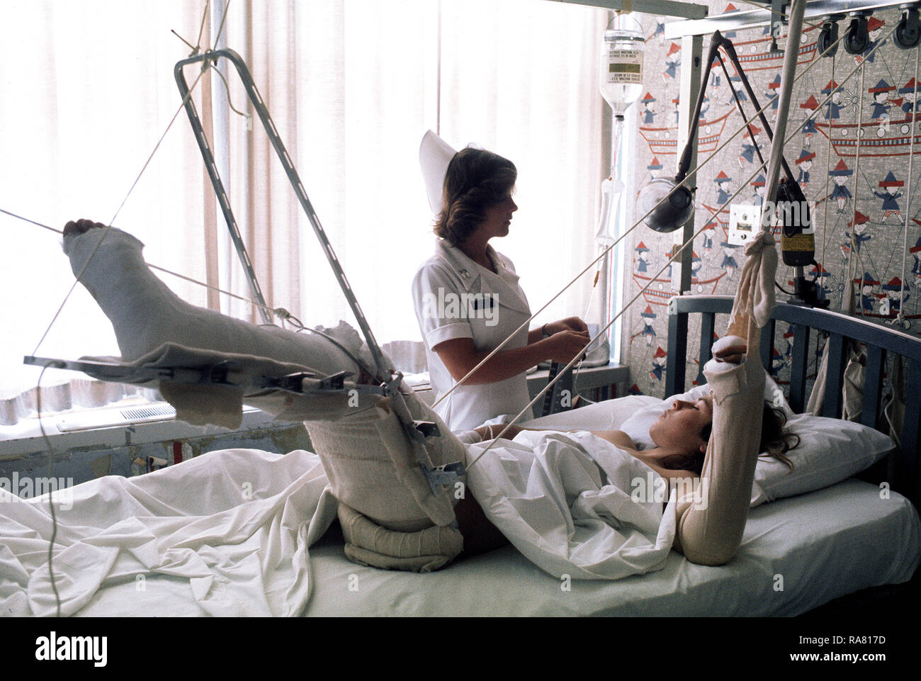 1976 - A nurse adjusts the intravenous feeding line on a patient Stock ...