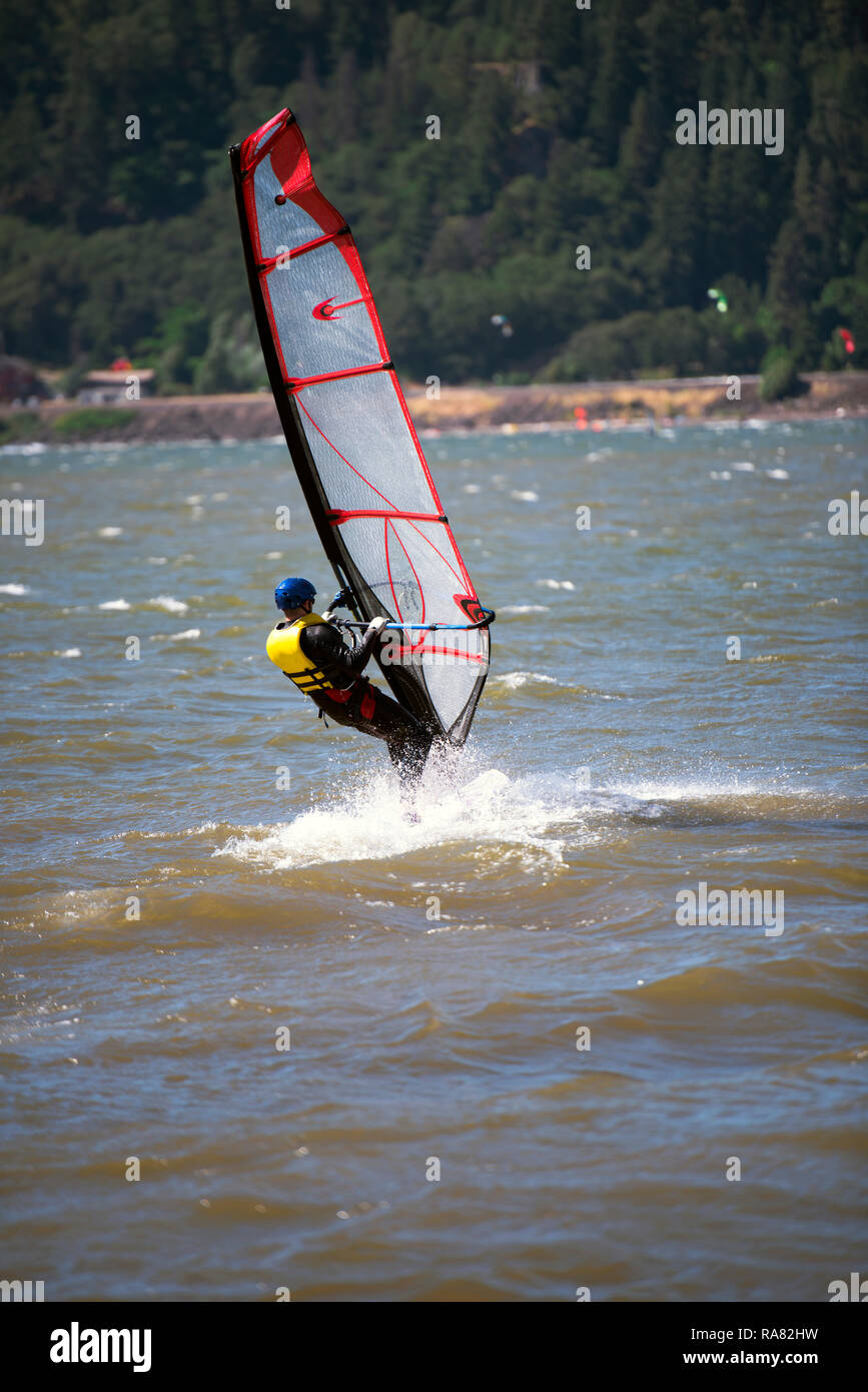 The surfer enjoying a walk with sail under the fresh wind along the ...