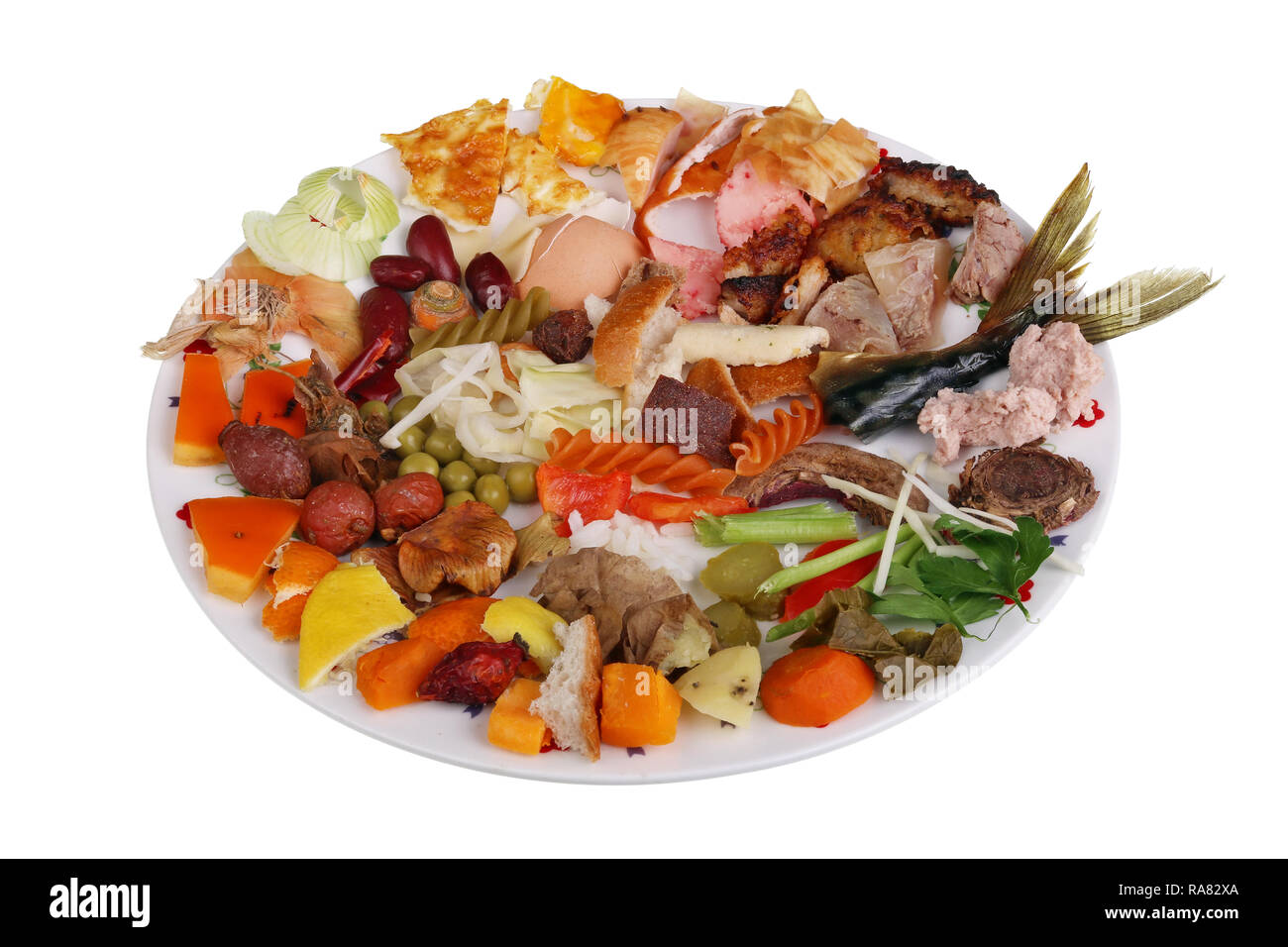 Food waste which remain after cooking on white plate. Isolated macro ...