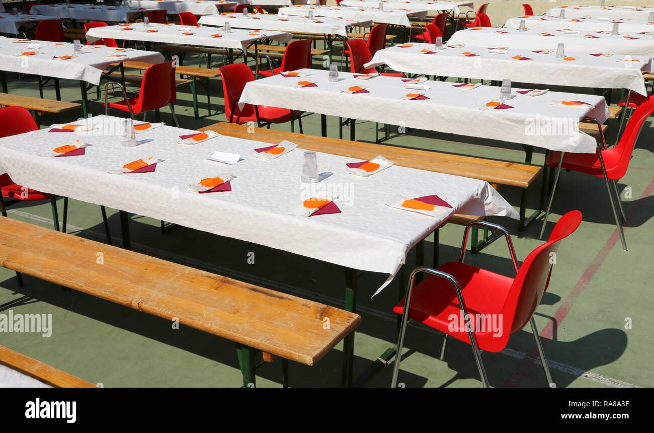 many tables set outdoors for a lunch with many guests Stock Photo - Alamy