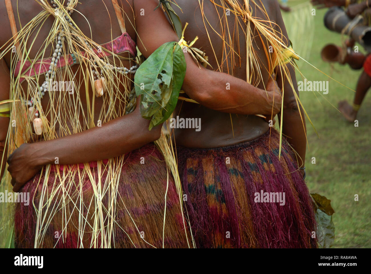 The back of two colourfully dressed and face painted women singing and ...