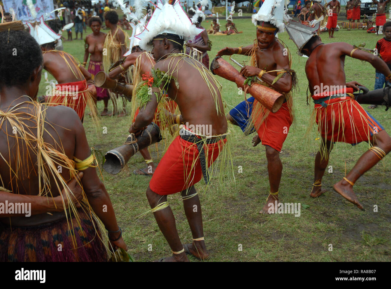 Colourfully dressed and face painted men singing and dancing at the ...