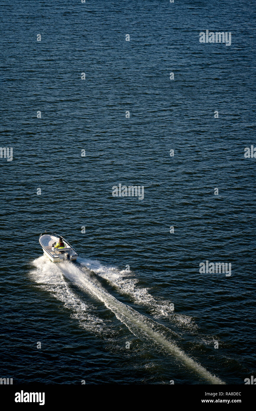 Fast pleasure motor boat with active lifestyle speeds through the dark ...