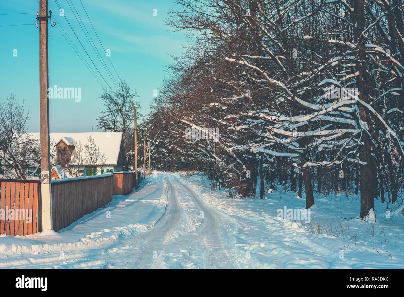 Rural winter landscape. Country road covered with snow between houses ...