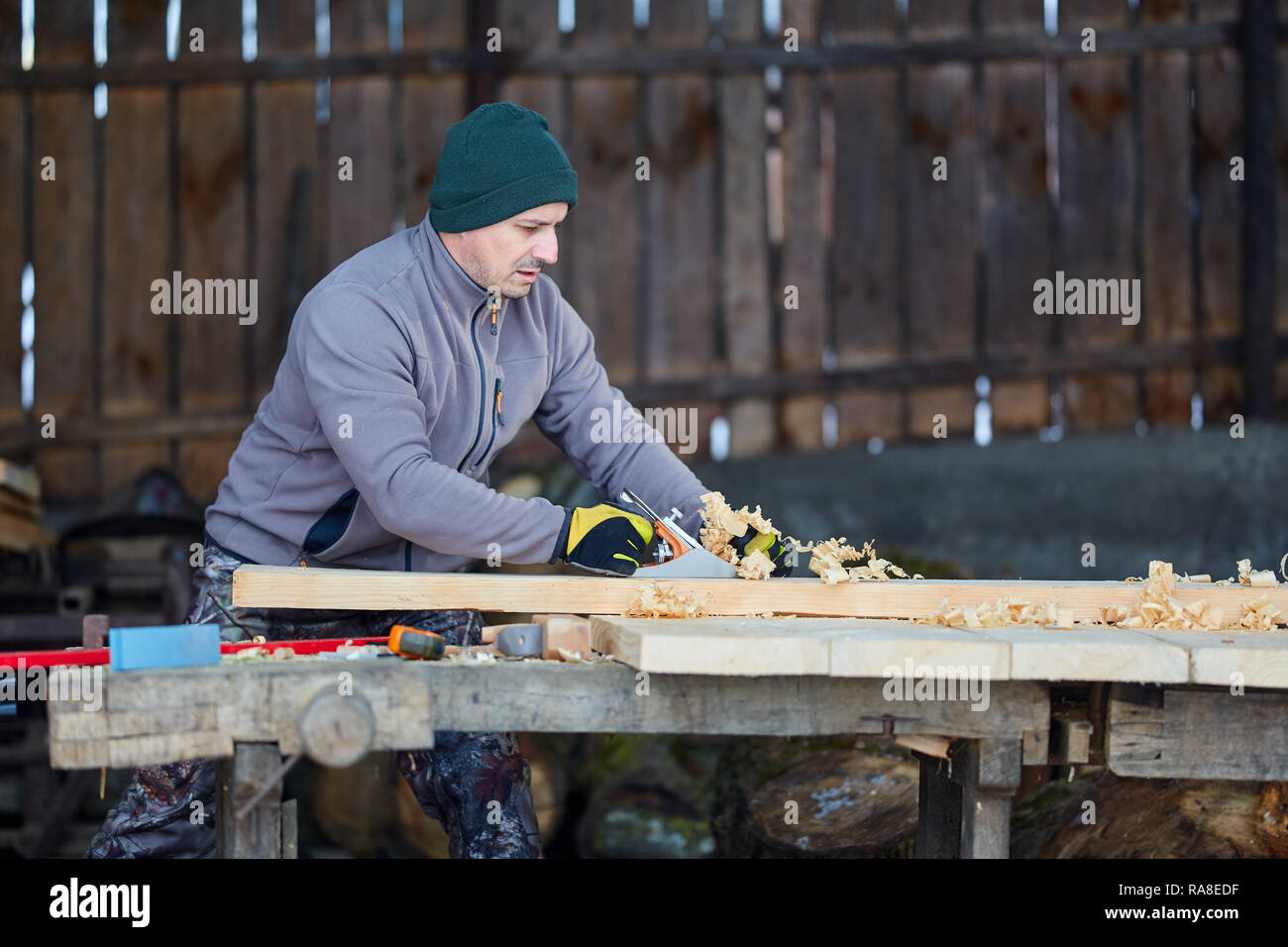 Woodworking - man using hand planer on a pine wood Stock Photo - Alamy