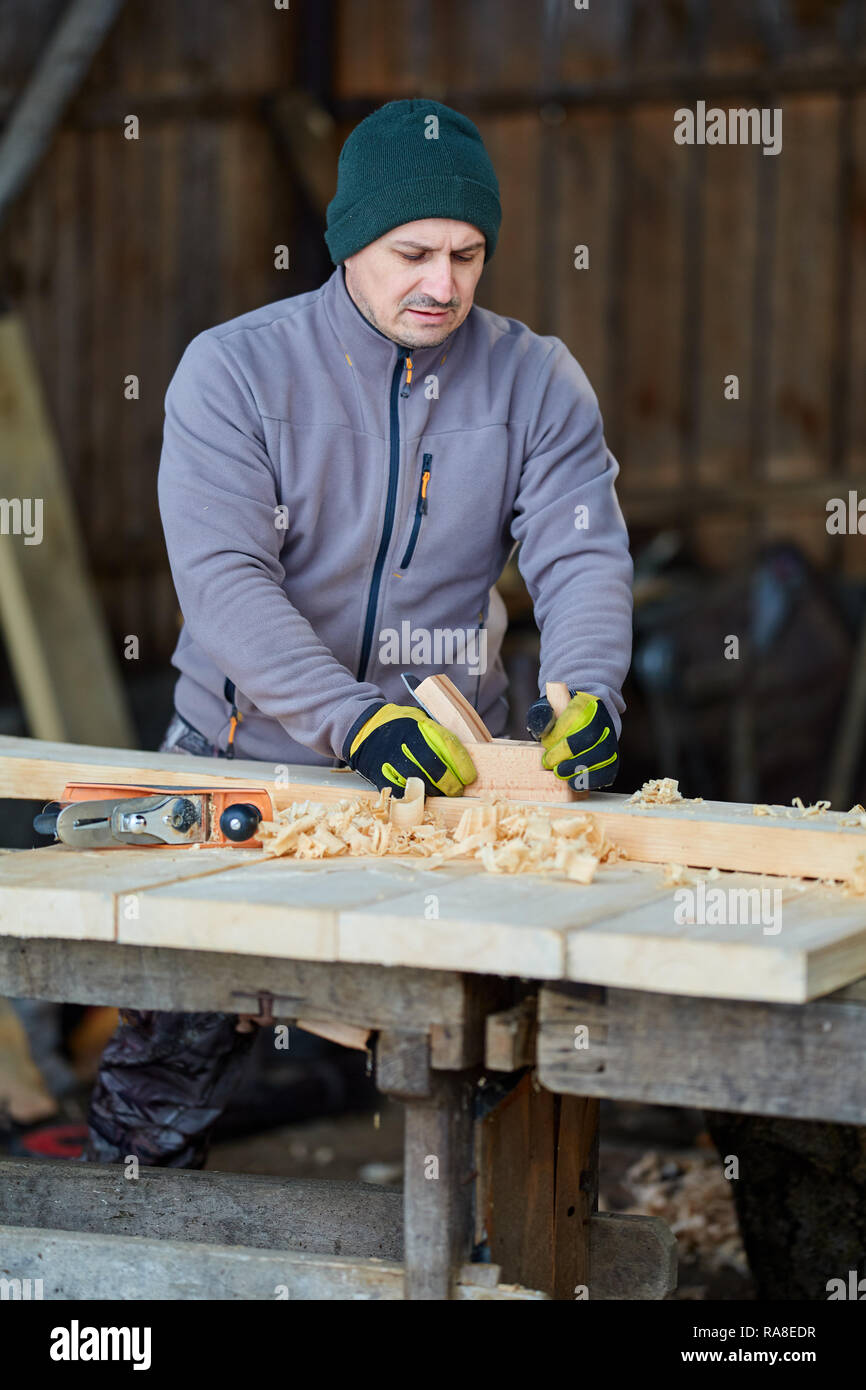 Woodworking - man using hand planer on a pine wood Stock Photo - Alamy