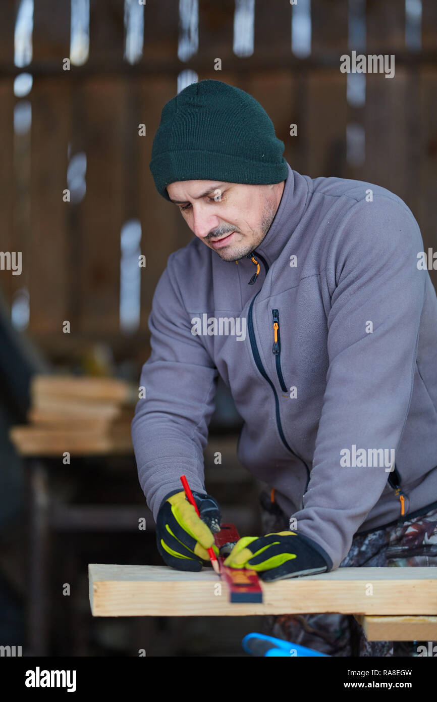 Woodworker measuring and drawing lines on his cabinet project Stock ...