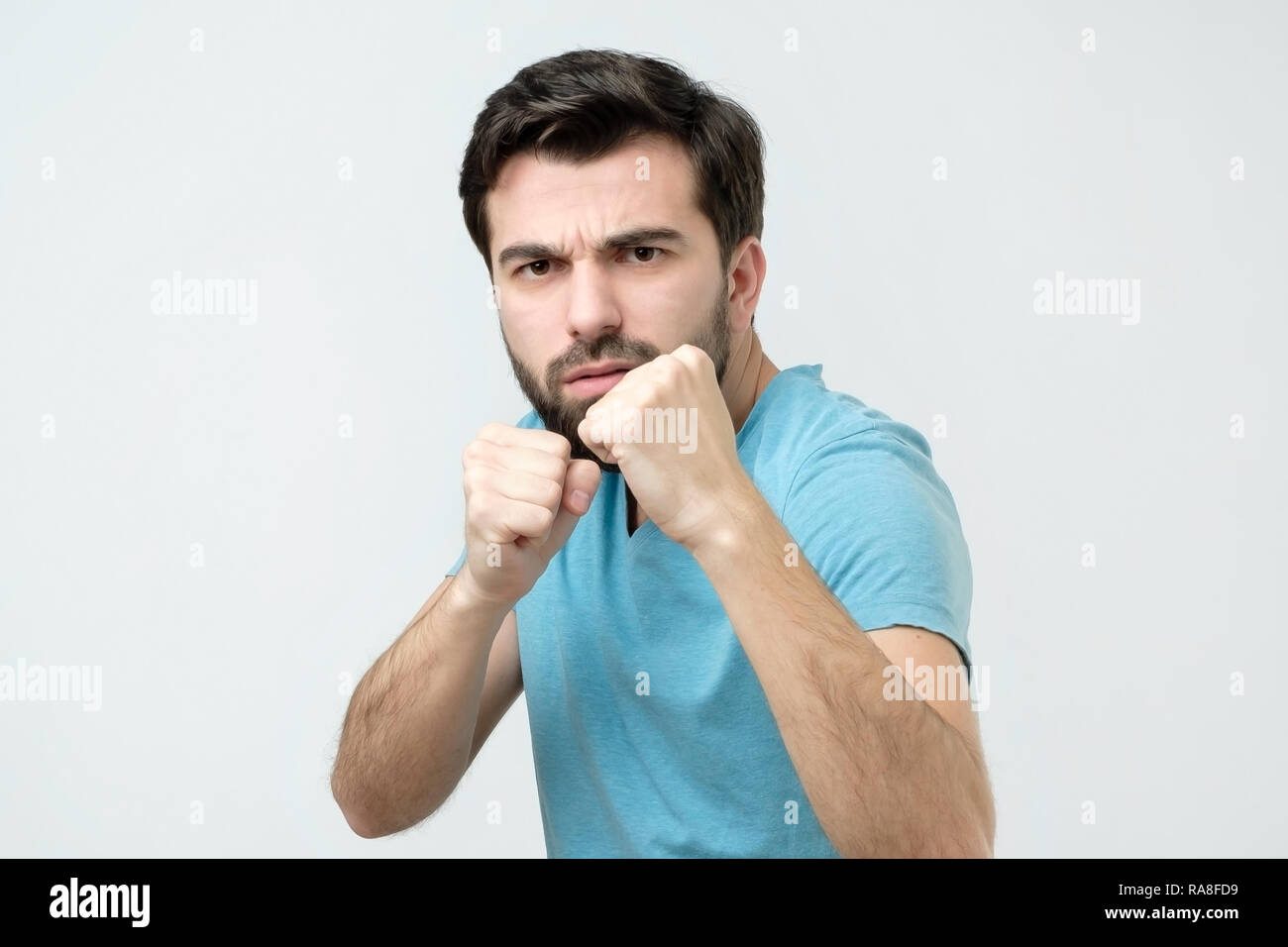 Handsome young hispanic man in fighting position. ready to protect ...