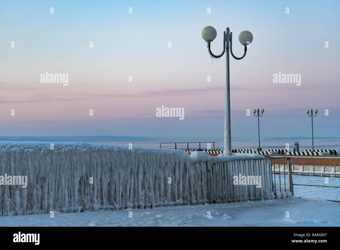 Winter landscape with icy fence on the background of the sky and the ...