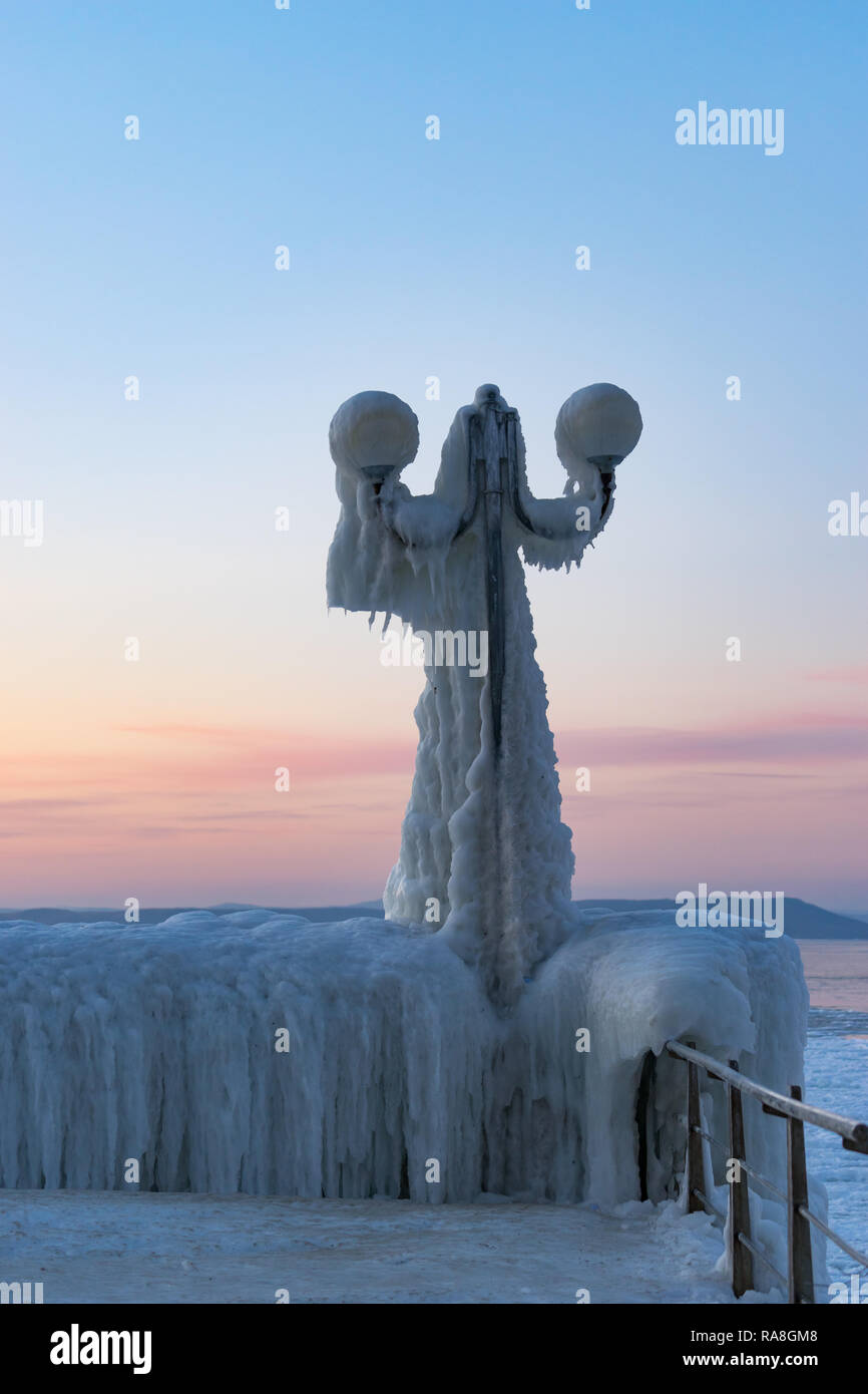 Winter landscape with icy fence on the background of the sky and the ...