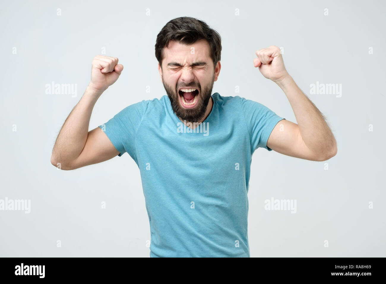 Successful young latin man with arms up. He is celebrating his victory ...