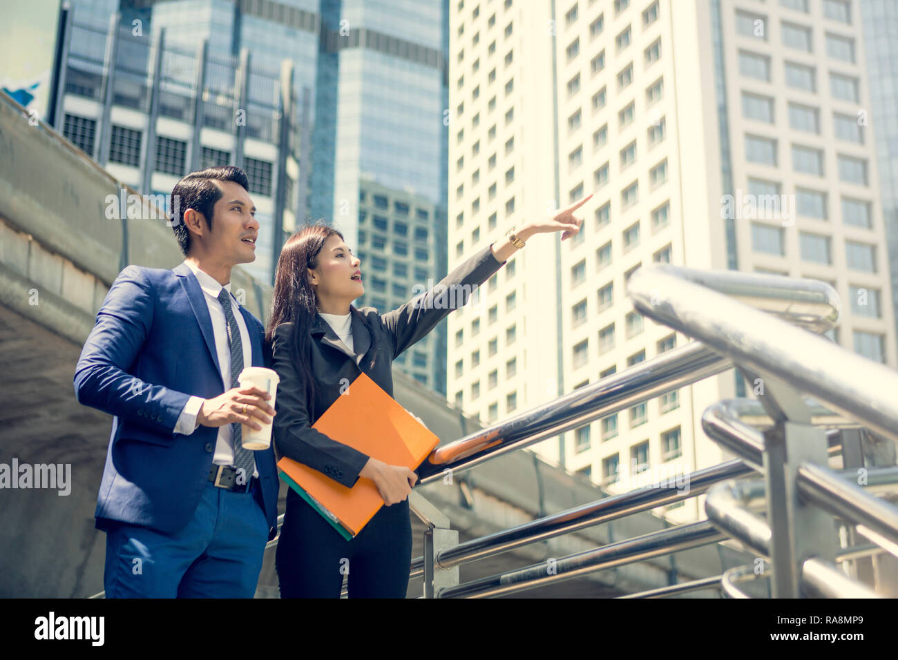 couple of Asian business peoples get vision by looking up to the future ...