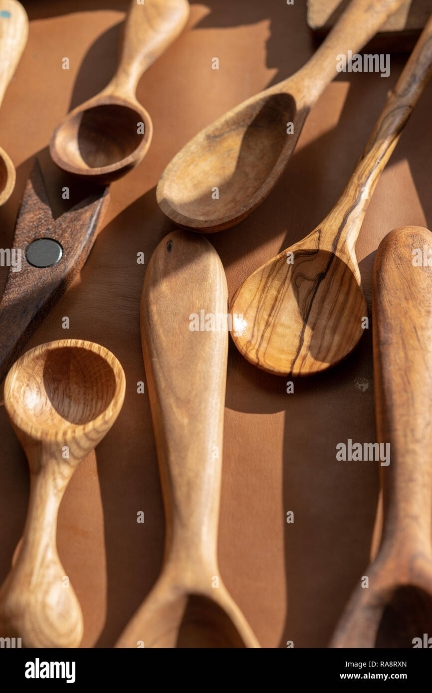 vertical view of spoons made of many different wood types sitting on a ...