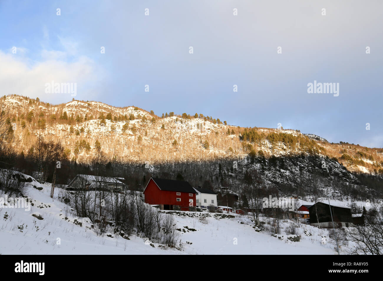 Sun shining on snowy mountain side with cabin Stock Photo - Alamy