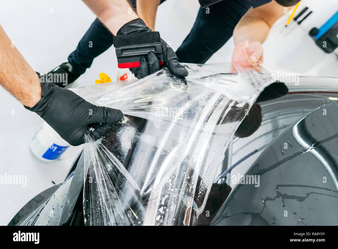 Car wrapping specialist putting vinyl foil or film on car. Protective ...